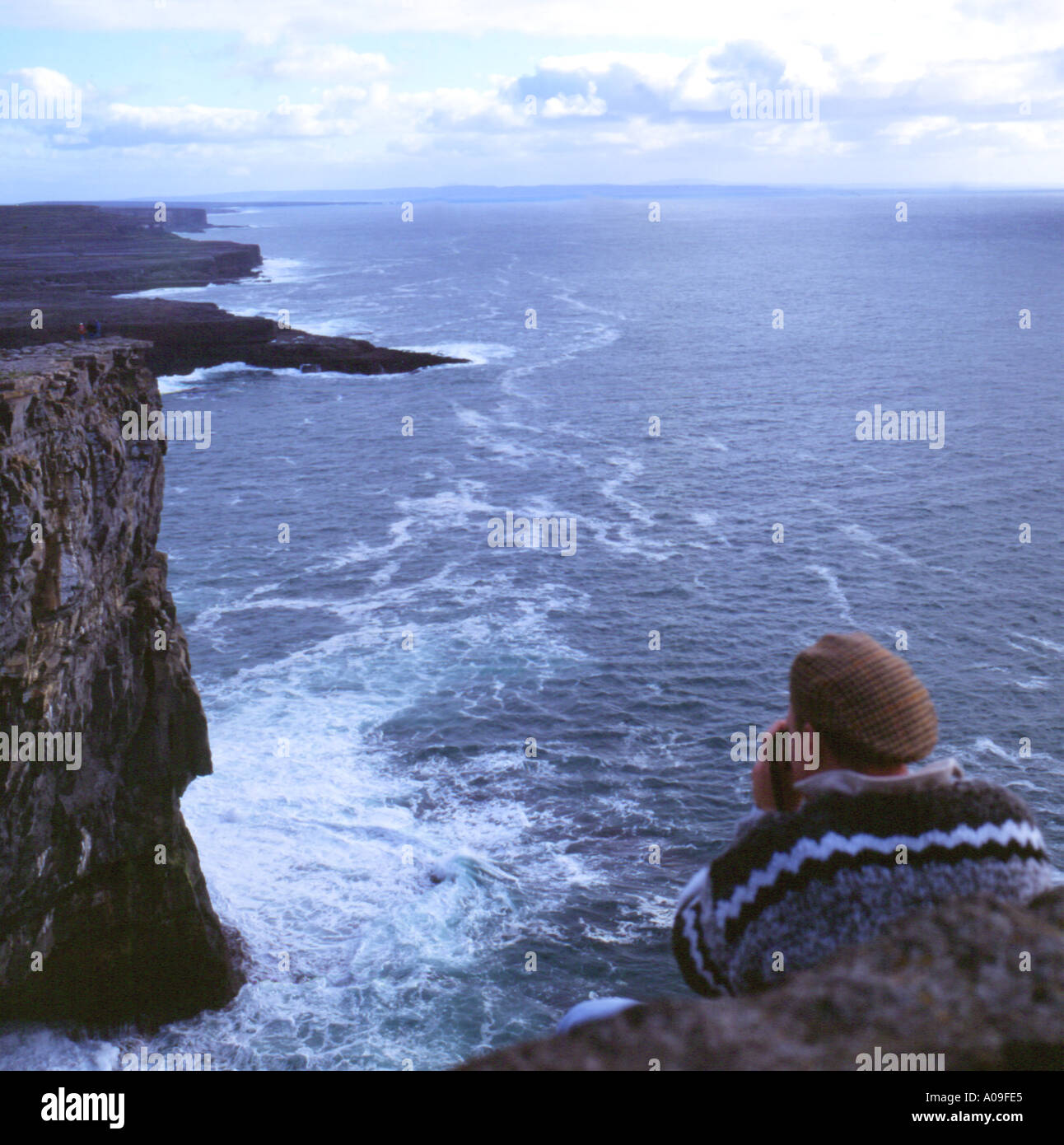 Man taking pictures of the breathtaking cliffs in Inishmore Aran ...