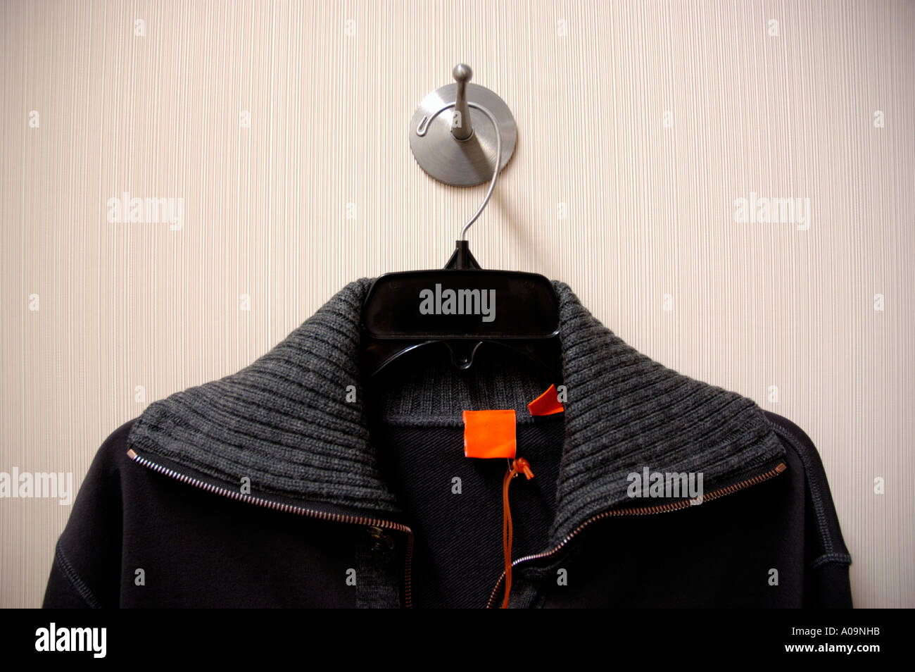 Jacket on hanger inside fitting room of store Stock Photo - Alamy