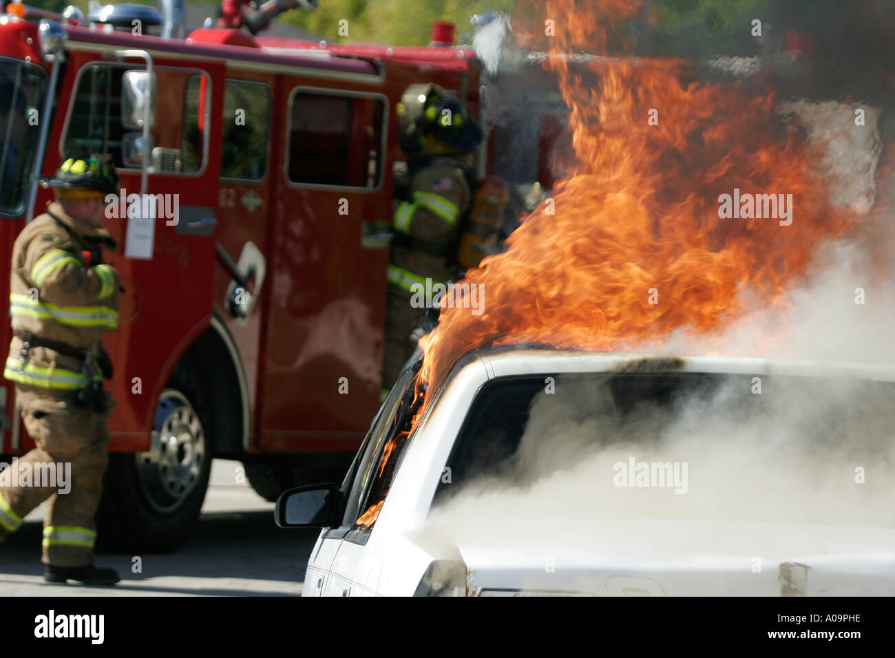 Car fire with fire fighters on scene Stock Photo - Alamy