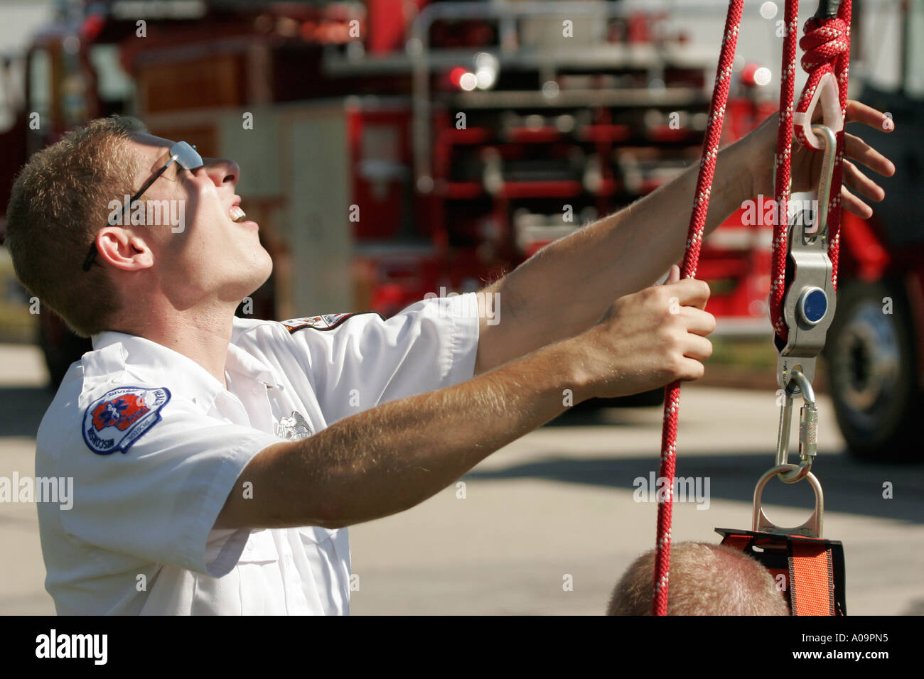 A fire fighter is holding the ropes for another fire fighter that is ...
