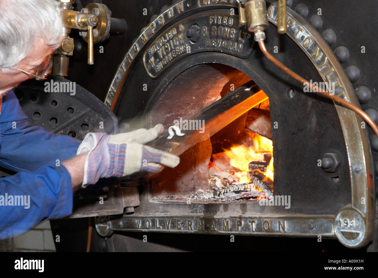 throwing wood and timber into a boil to raise the steam to power a ...