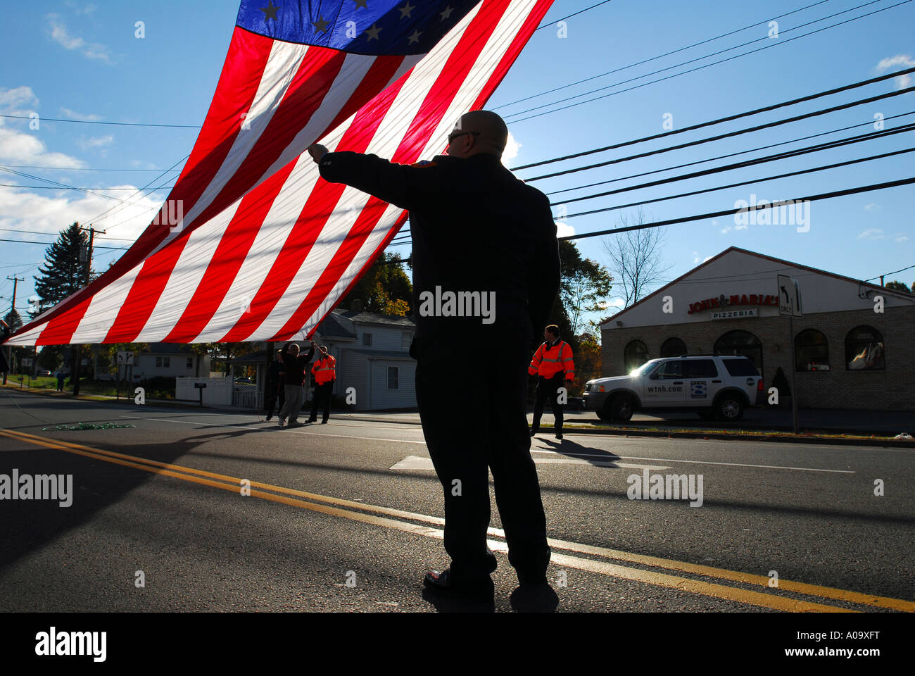 Firefighters set up a massive flag before a funereral procession for a ...