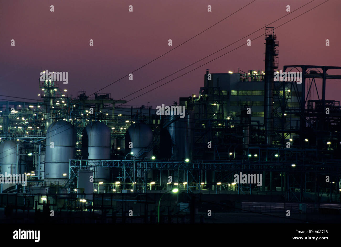 Illuminated storage tanks at a petroleum refinery at sunset, Berre ...