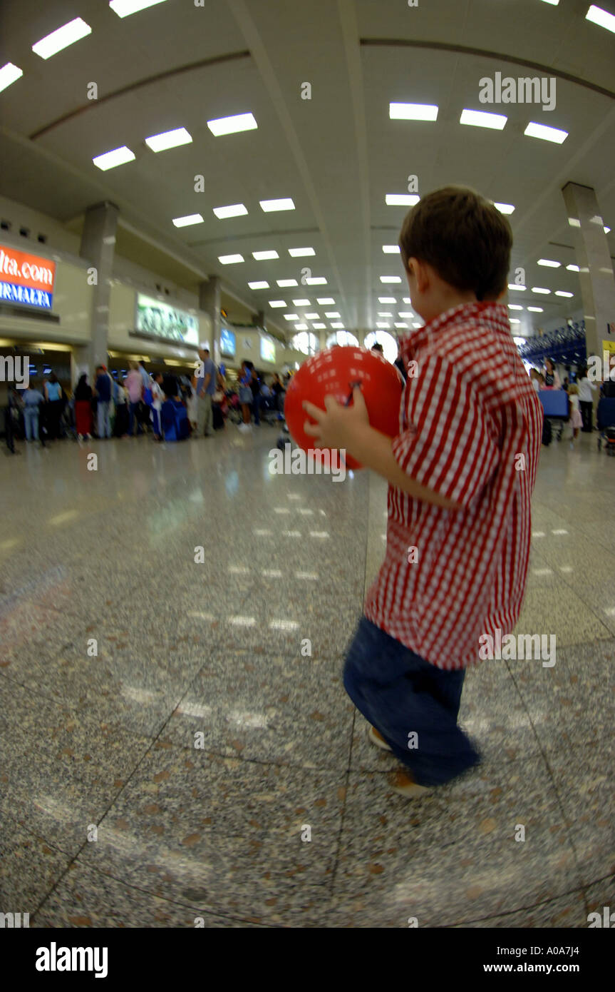 boy playing with red ball at airport check-in Stock Photo - Alamy