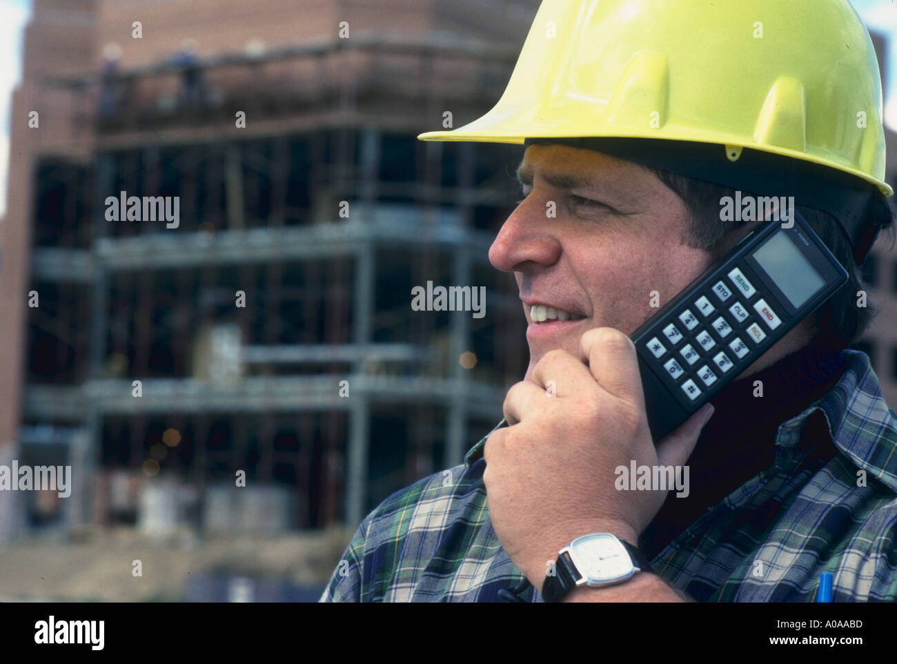Construction supervisor uses cellular phone from construction site ...