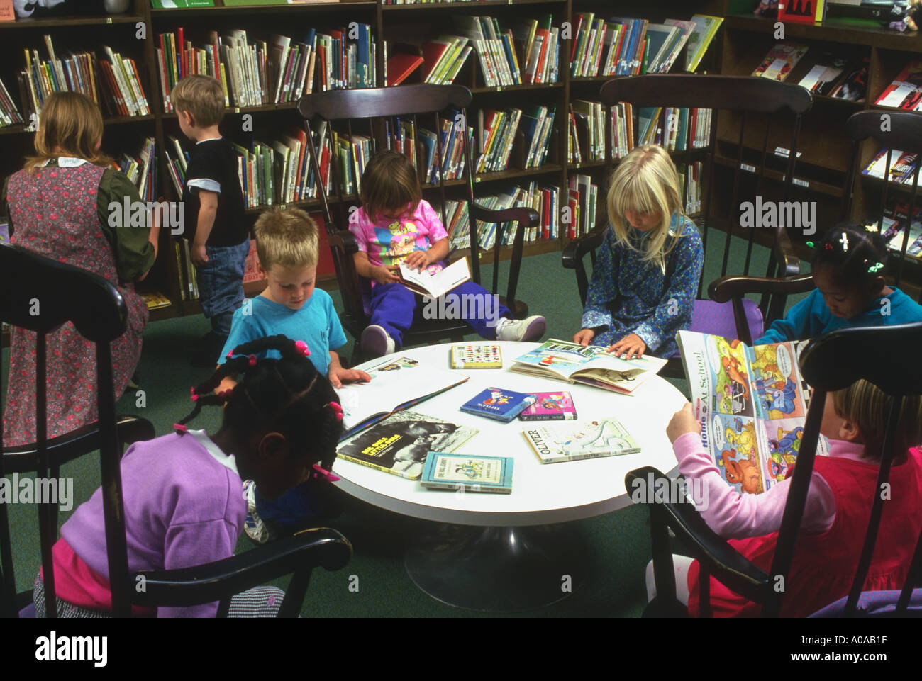 Preschool children reading books at library model released Stock Photo ...