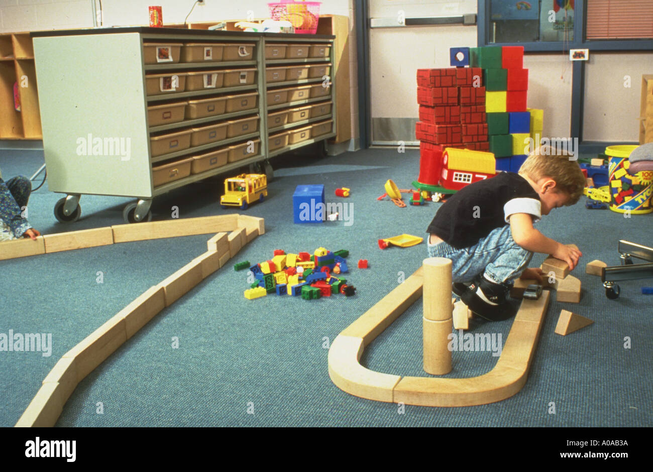 Preschool children playing with development material blocks etc model ...