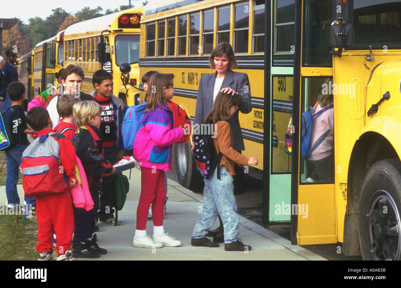 Elementary school students getting on bus model released Stock Photo ...