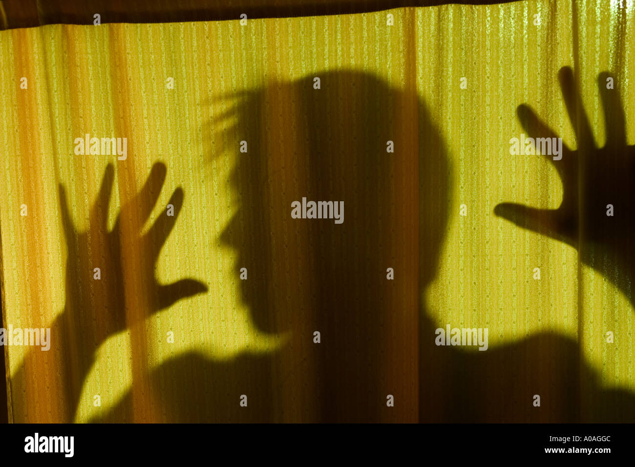 Man hiding behind a yellow curtain Stock Photo - Alamy