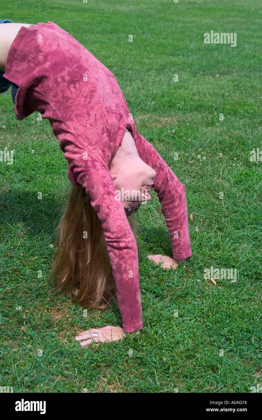 Young woman with long hair and wearing glasses lying in a contorted ...
