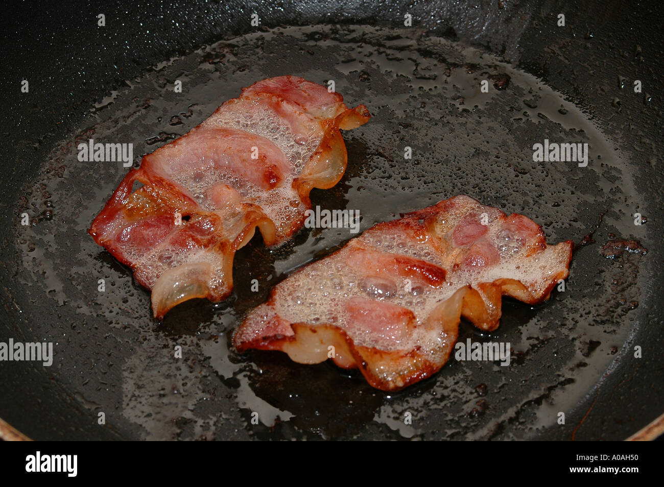 Bacon sizzling in a fry pan, Australia Stock Photo - Alamy