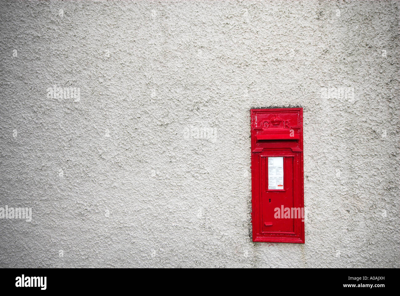 Red post box in a white wall Stock Photo - Alamy