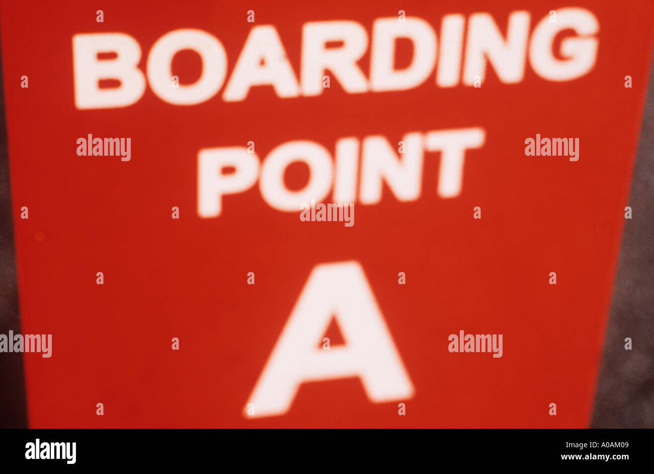 Defocussed red board with white lettering declaring Boarding point A ...