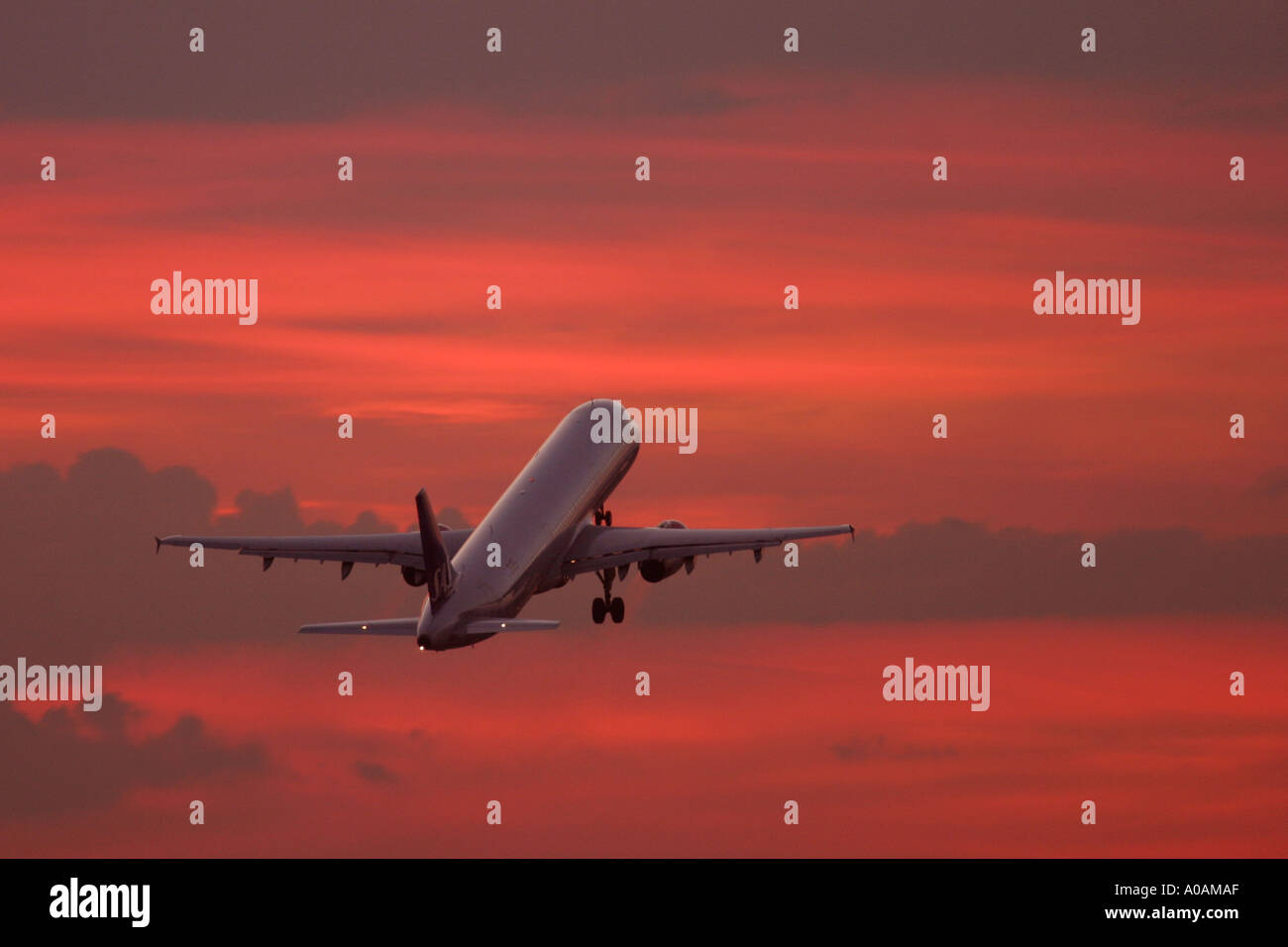 Aeroplane taking off against red sky Stock Photo - Alamy