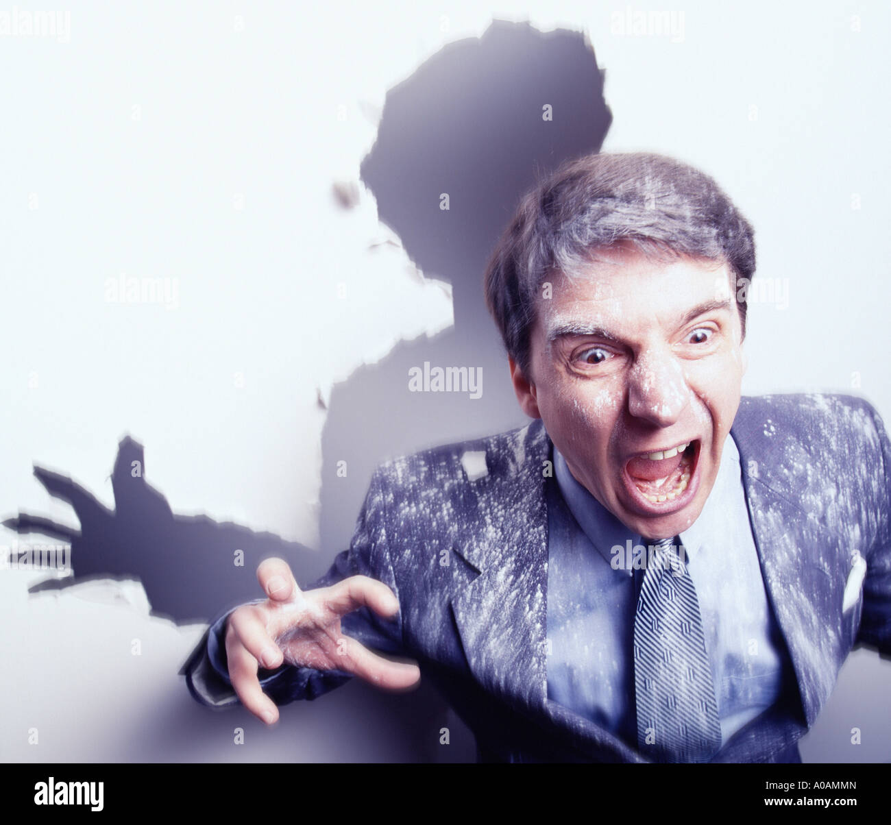 Frustrated businessman breaking through wall Stock Photo - Alamy