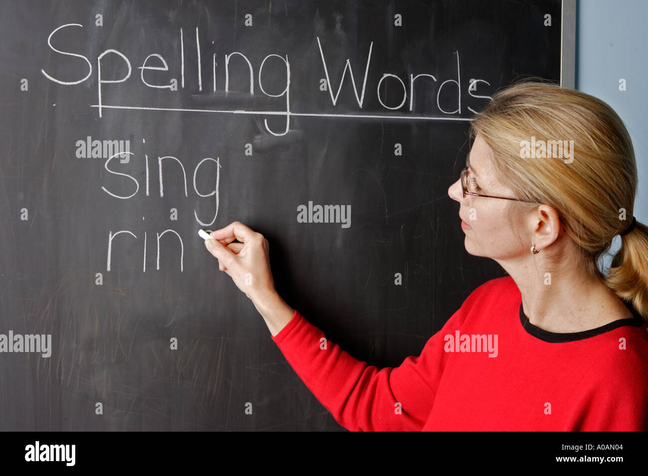 Teacher writing spelling words on a blackboard Stock Photo - Alamy