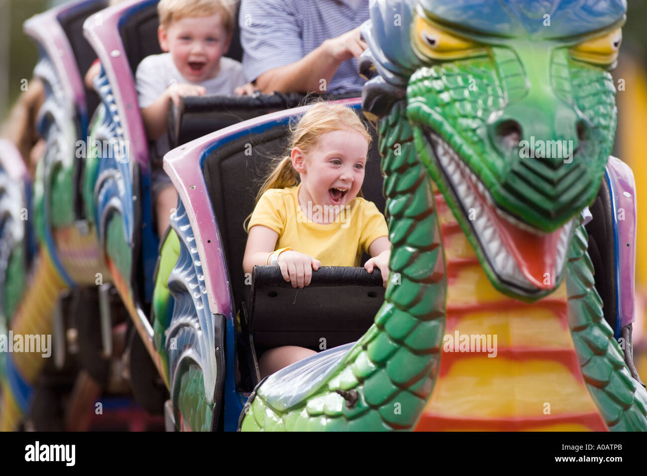 Little Caucasian girl riding kiddy roller coaster Stock Photo - Alamy
