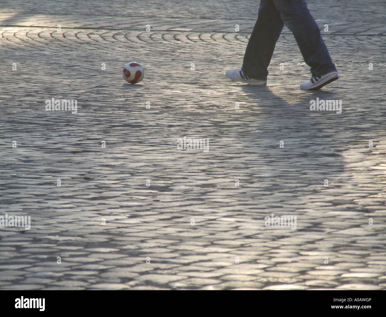 football player shadow on cobbled street Stock Photo - Alamy