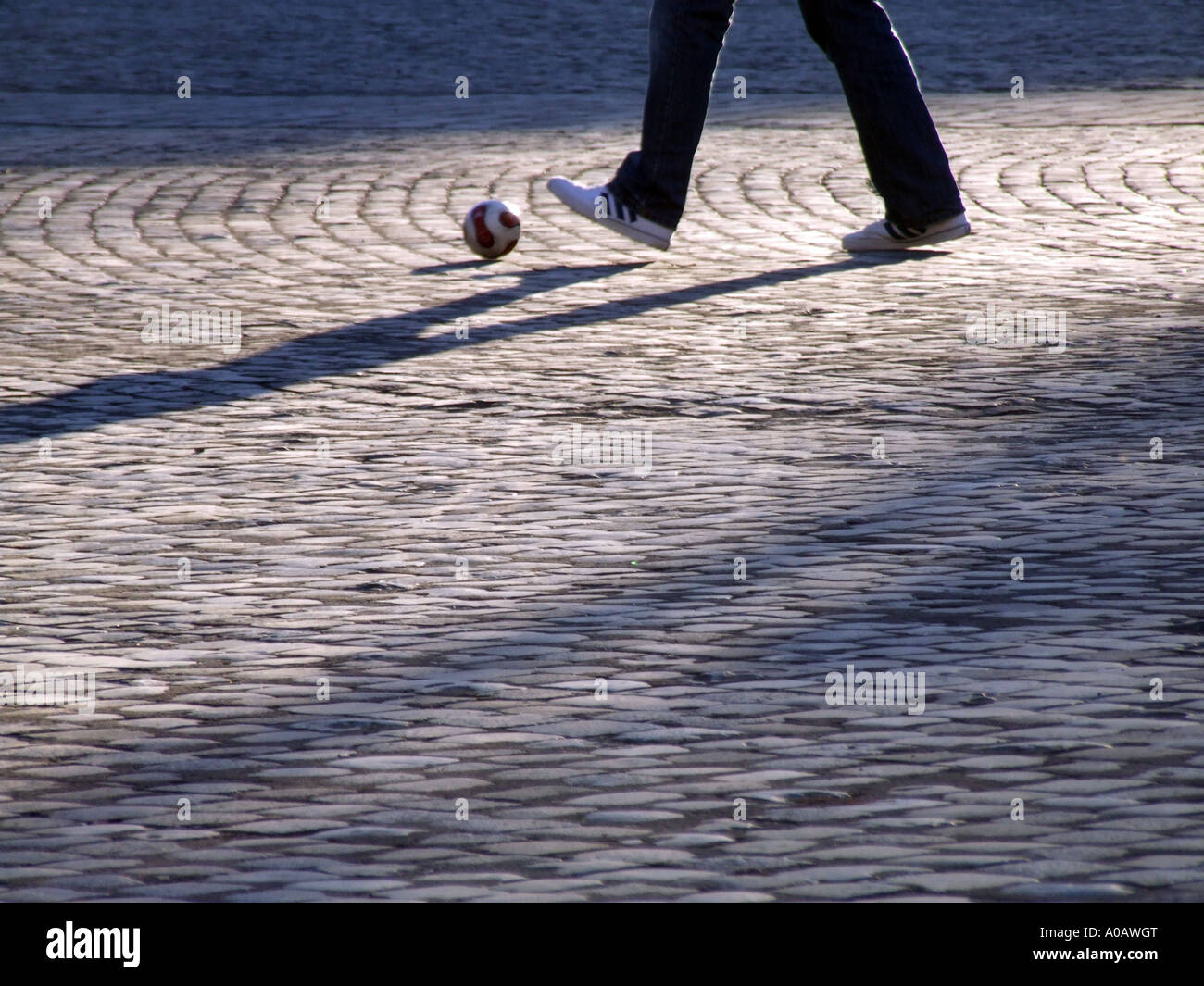 football player shadow on cobbled street Stock Photo - Alamy