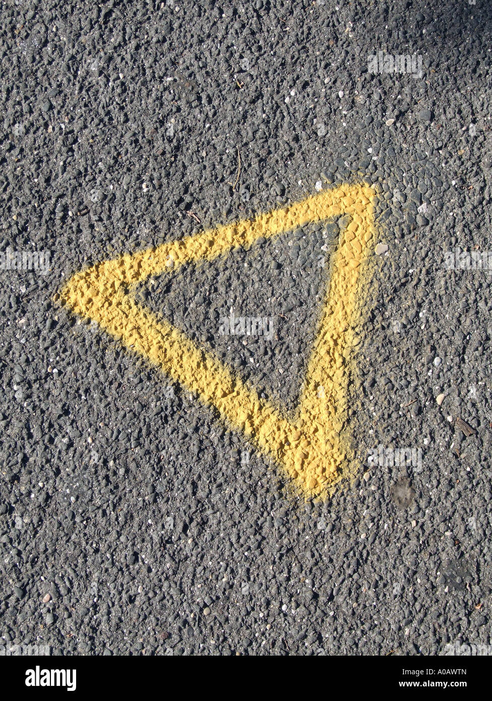 yellow triangle painted on road Stock Photo - Alamy