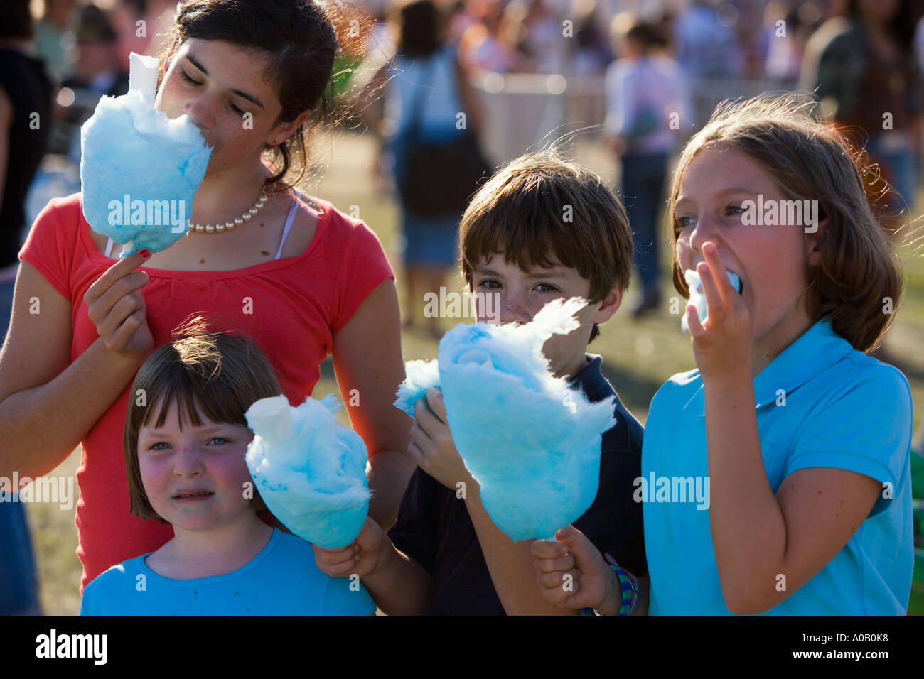 Four siblings eating blue cotton candy Stock Photo - Alamy