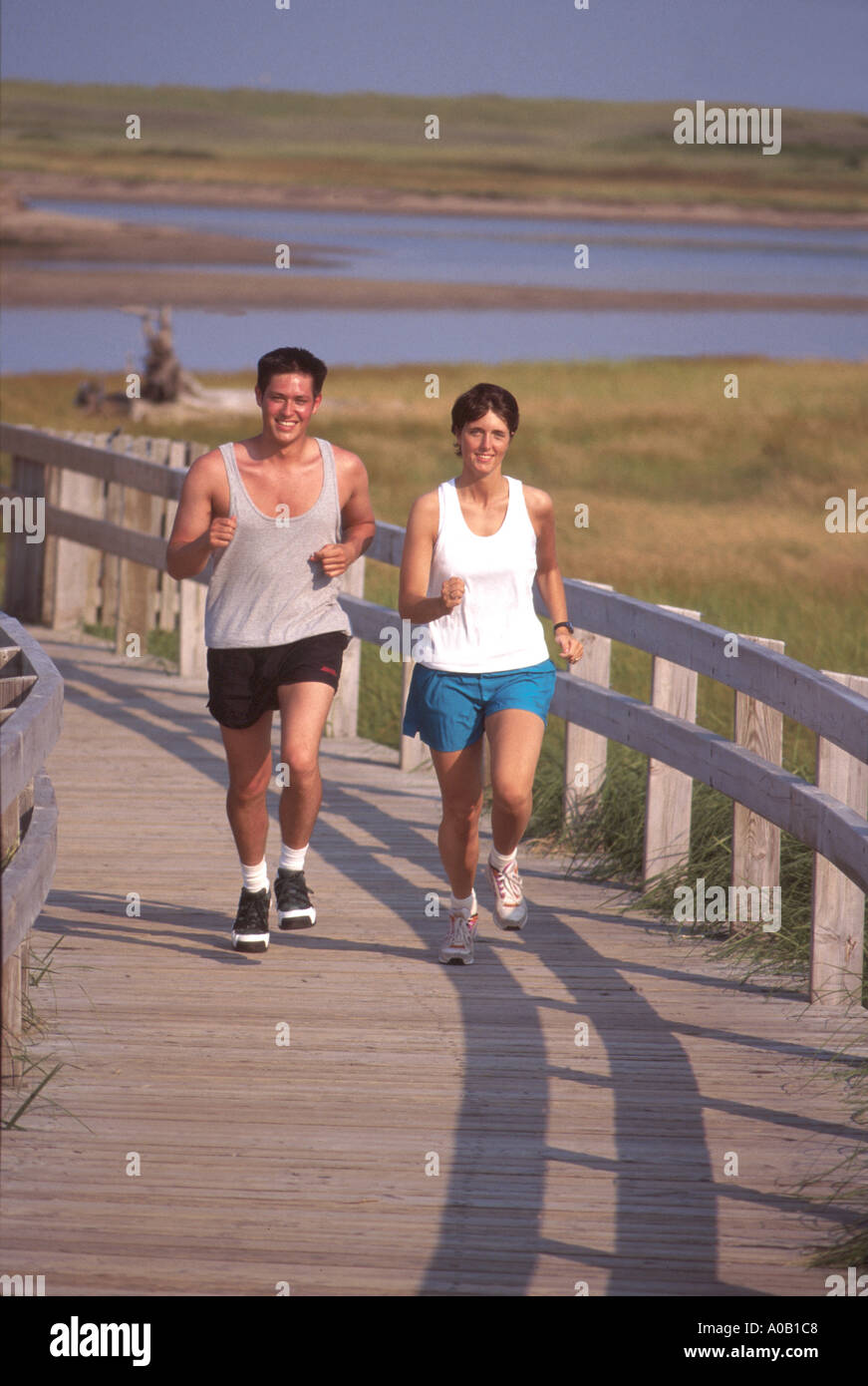 Young couple running on walkway or boardwalk in New Brunswick Canada ...