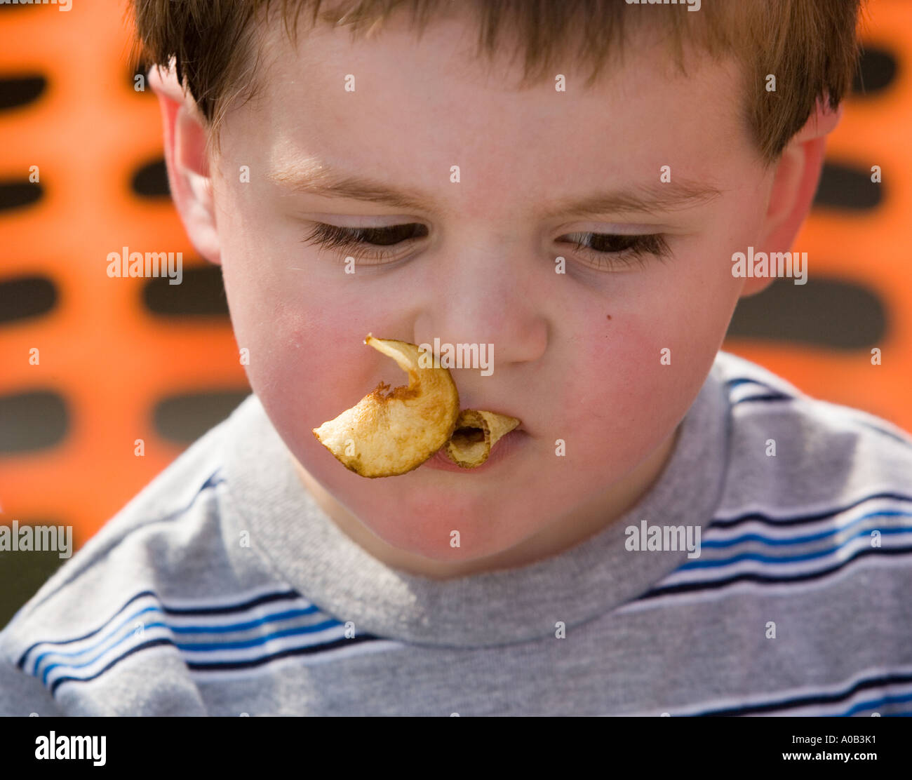 Portrait Caucasian boy eating potato chips Stock Photo - Alamy