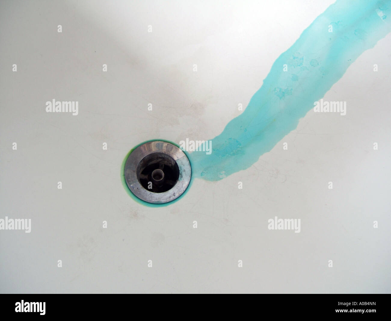 blue green liquid spillage going down plug hole Stock Photo - Alamy