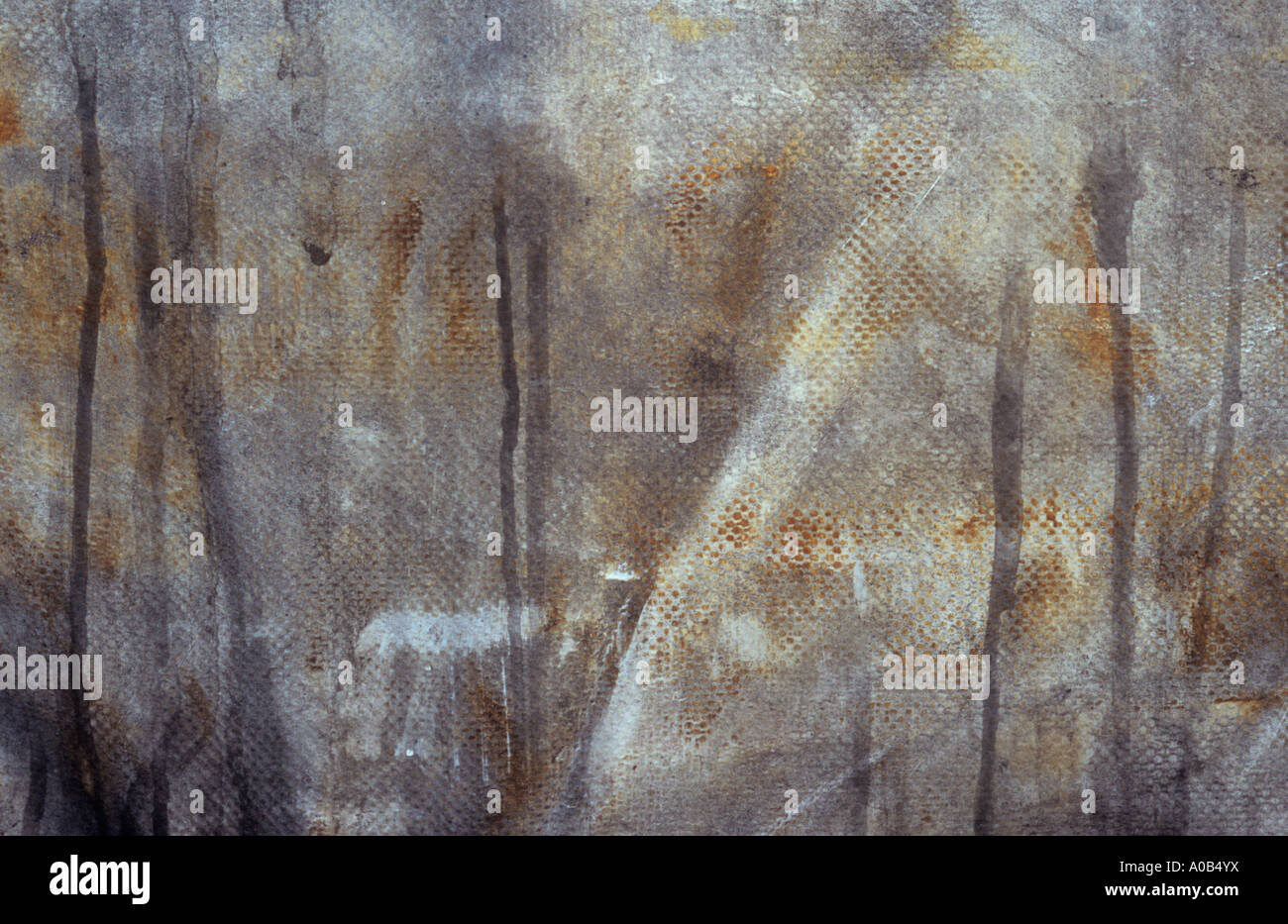 Detail of white plastic or nylon tarpaulin sheet with rust stains and ...