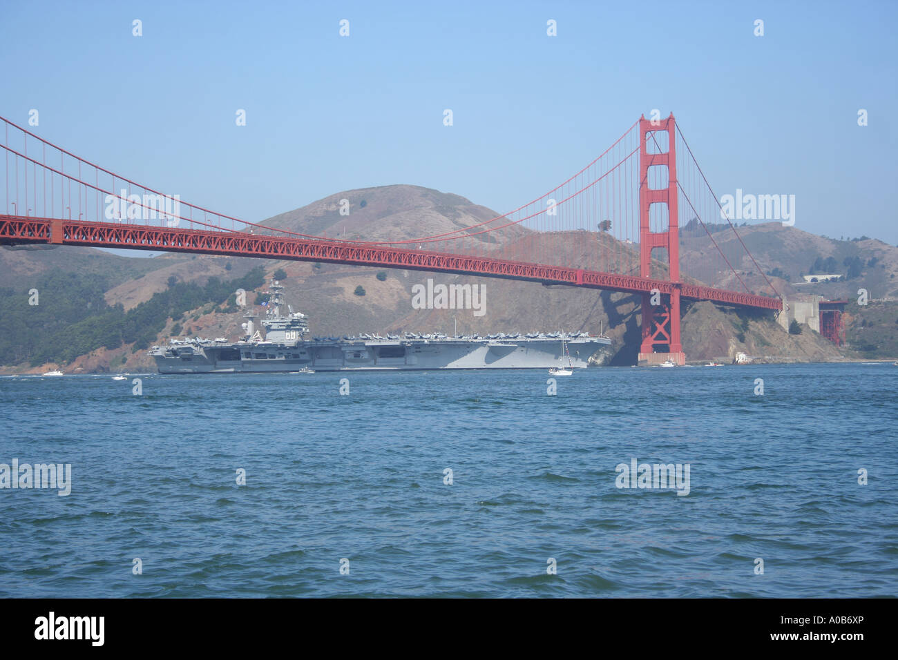 American aircraft carrier naval vessel passing under Golden Gate Bridge ...