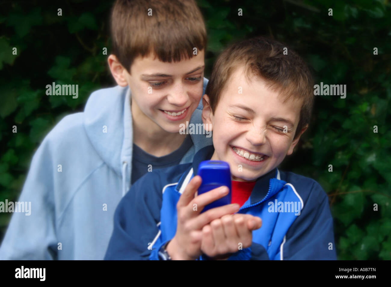 Two boys looking at phone hi-res stock photography and images - Alamy