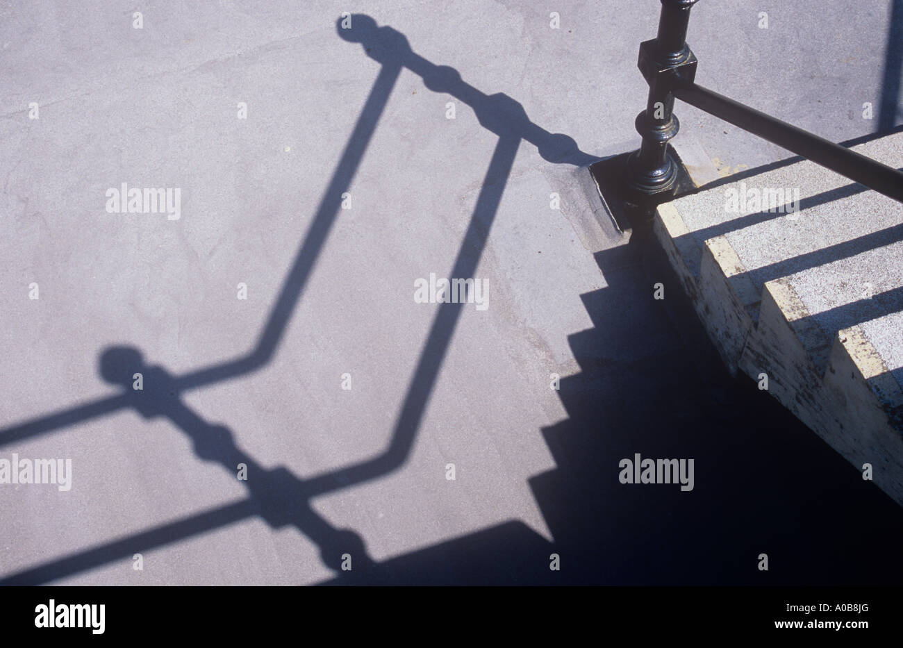 View from above of railings and steps in strong sunlight casting deep ...
