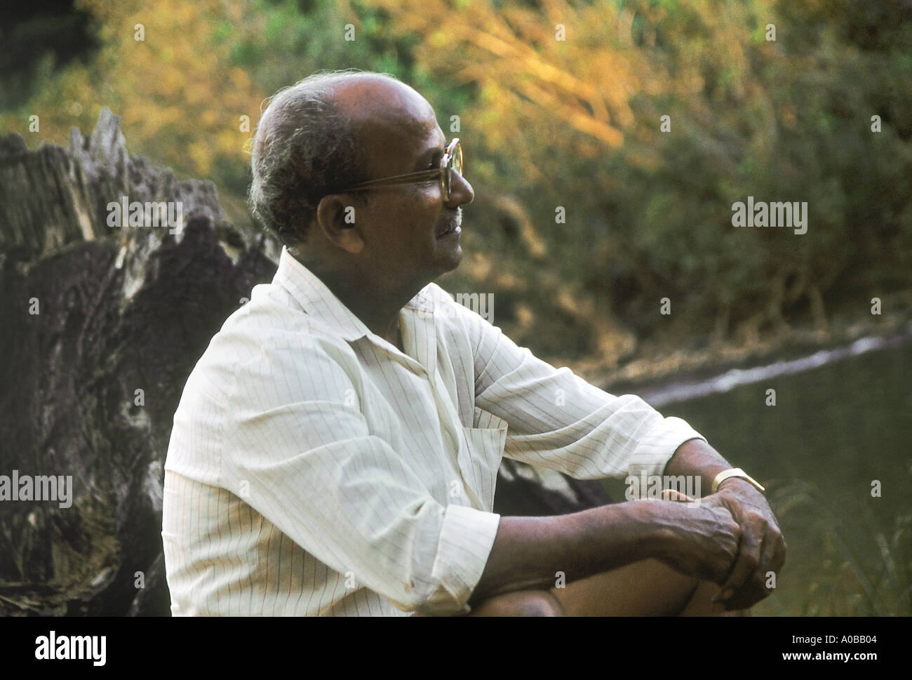 A man sitting near a river Stock Photo - Alamy