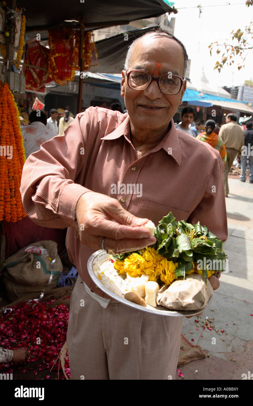 Man offering prasad outside Pracheen Hanuman Mandir, Connaught Place ...