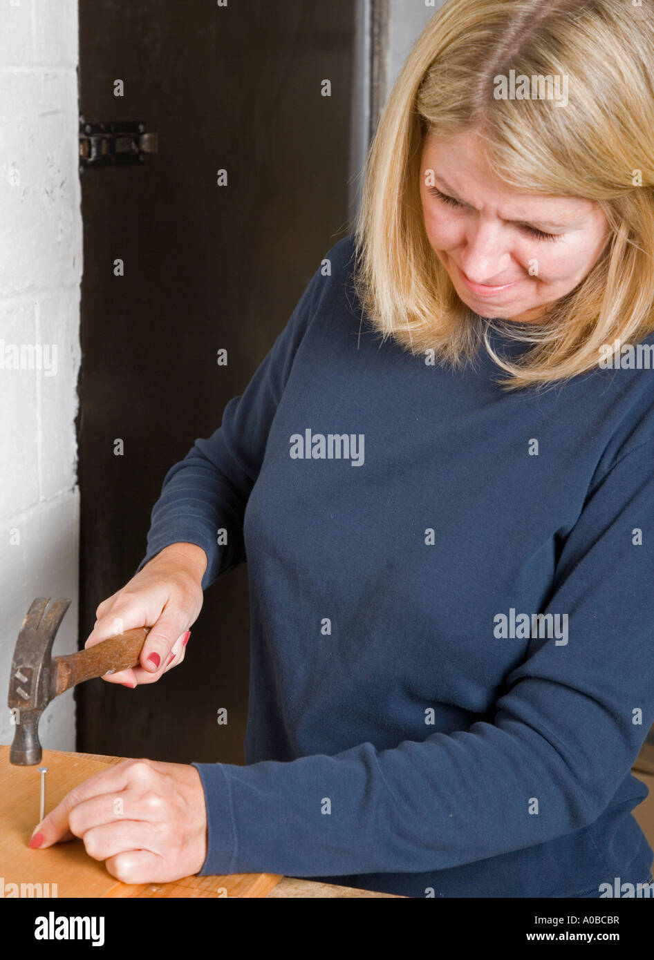 Woman hammering a nail hi-res stock photography and images - Alamy