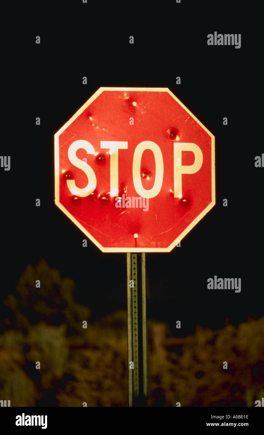 Stop sign with bullet holes scattered across it Stock Photo - Alamy