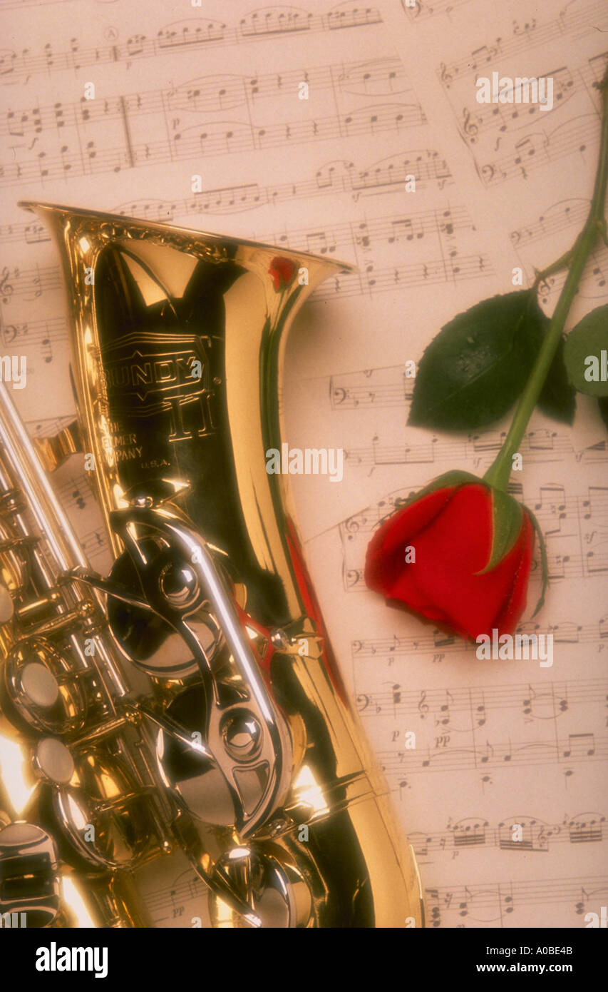 Saxophone and red rose laying on sheet music Stock Photo - Alamy