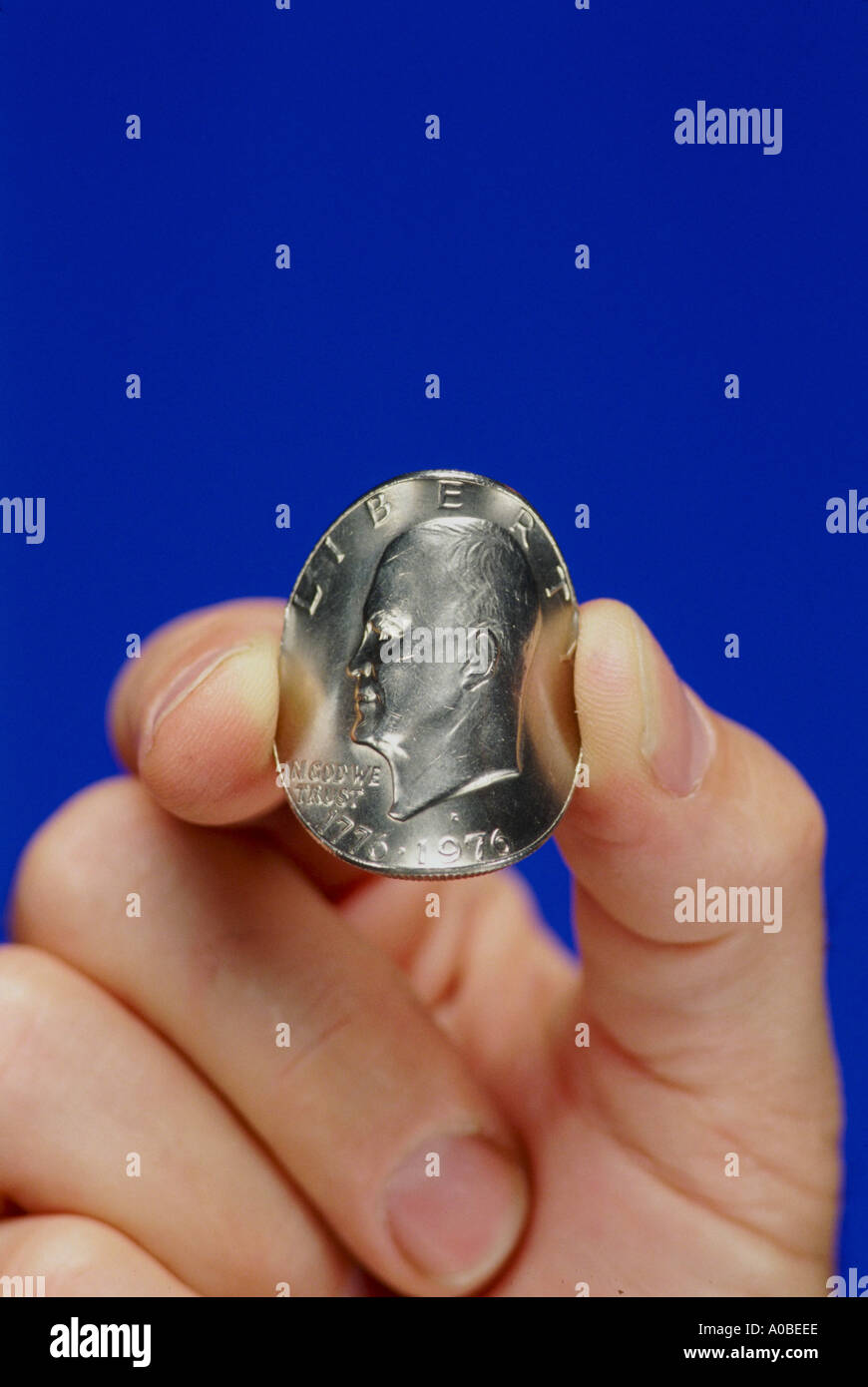 Hand pinching a silver dollar Stock Photo - Alamy