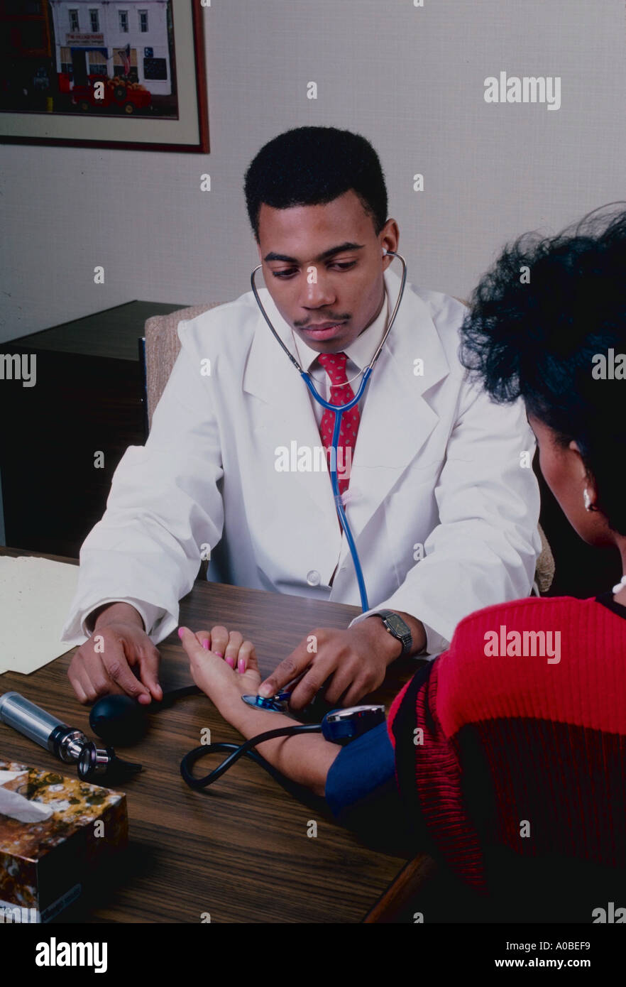 Medical technician Jessie Miles taking blood pressure of female patient ...