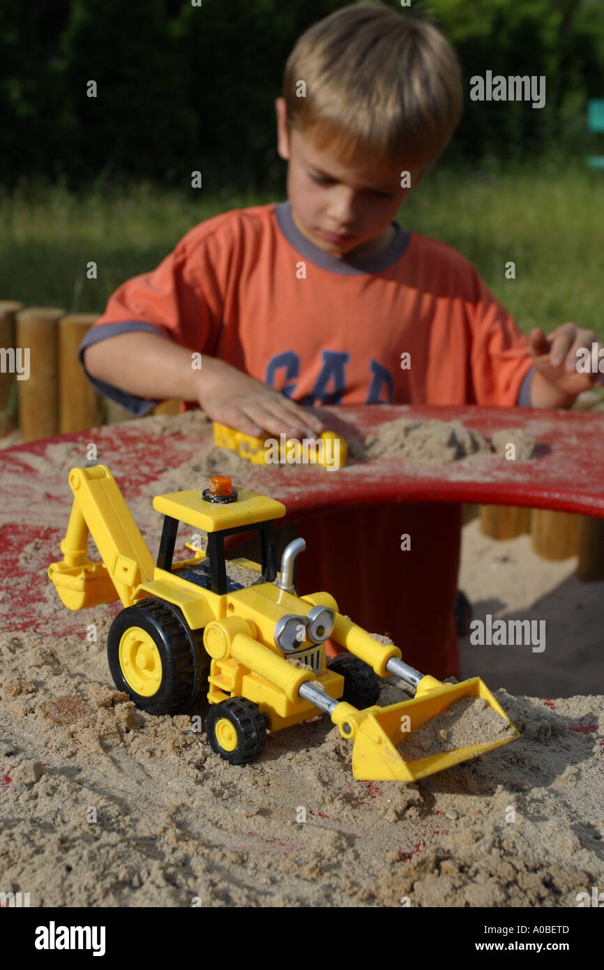 Young boy playing in sandpit with toy digger Stock Photo - Alamy