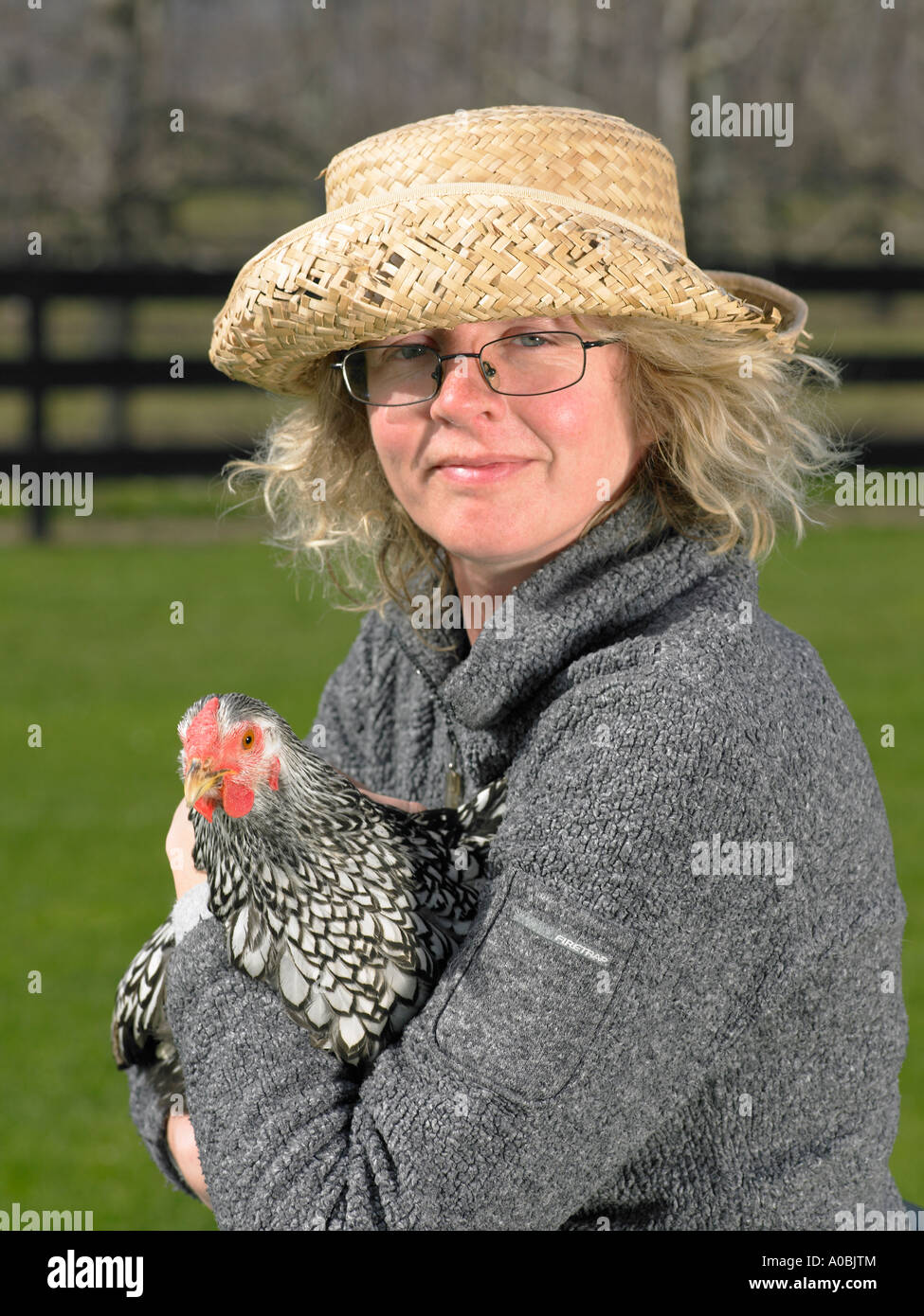 woman holding her pet chicken hen wearing hat in the summer Stock Photo ...