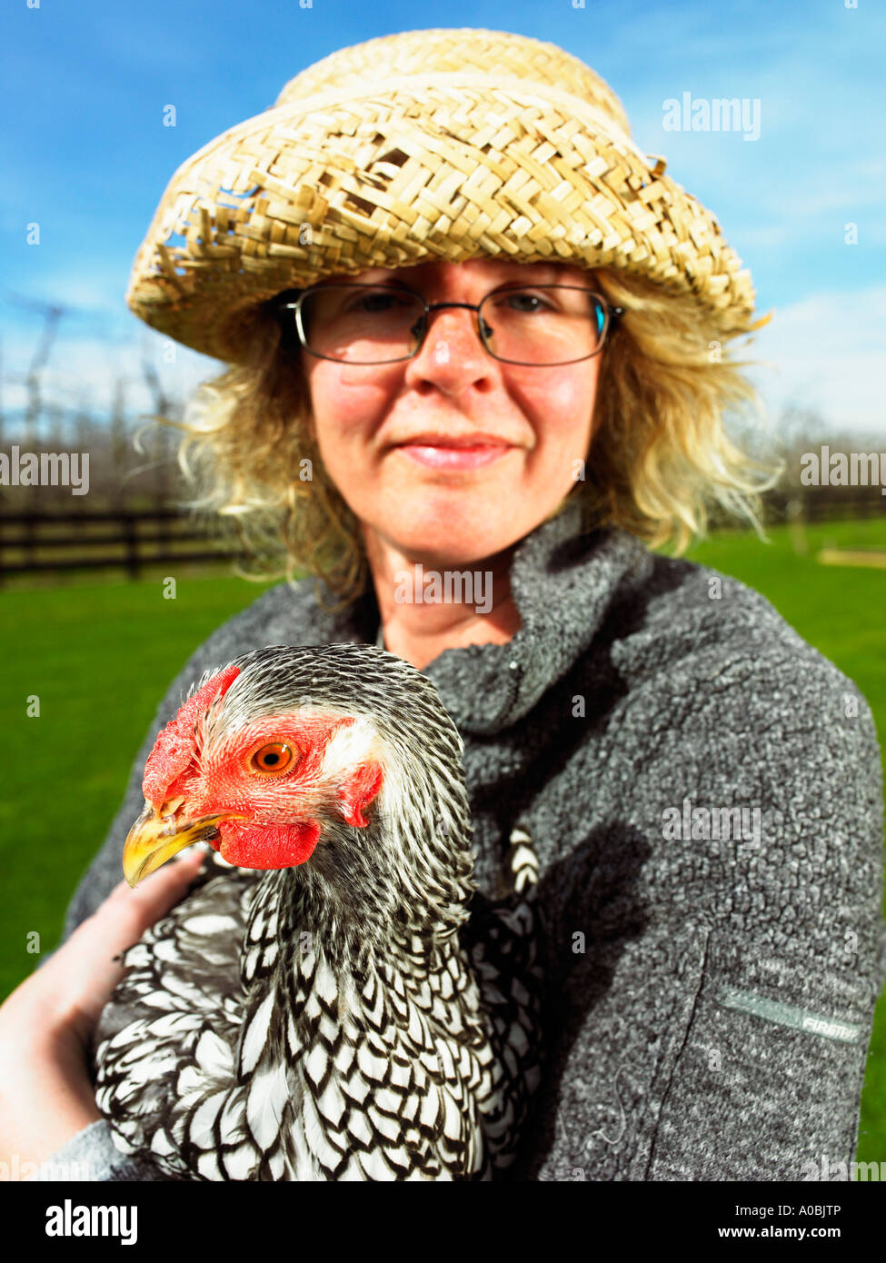 woman holding her pet chicken hen wearing hat in the summer Stock Photo ...
