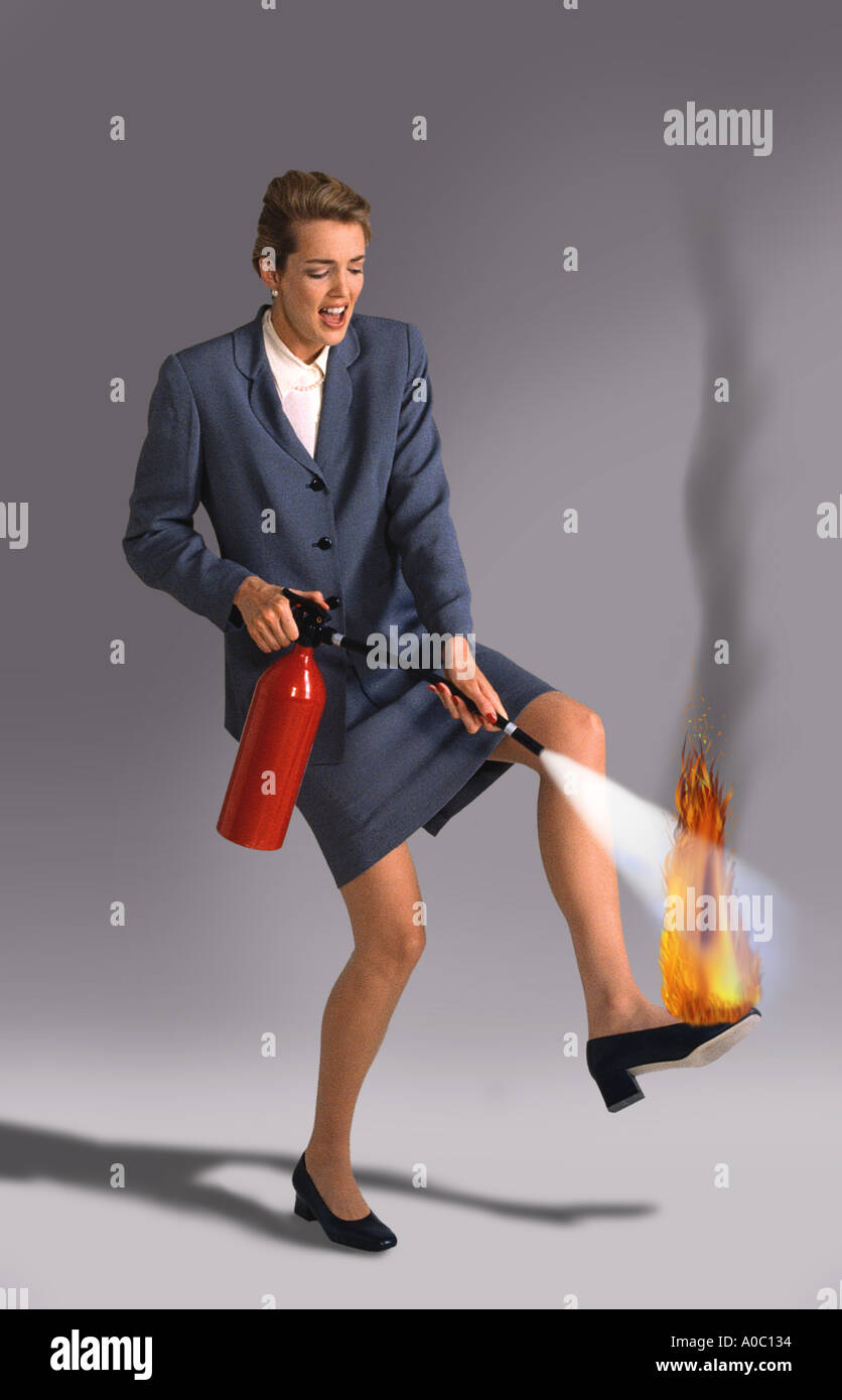 Businesswoman with foot on fire Stock Photo - Alamy