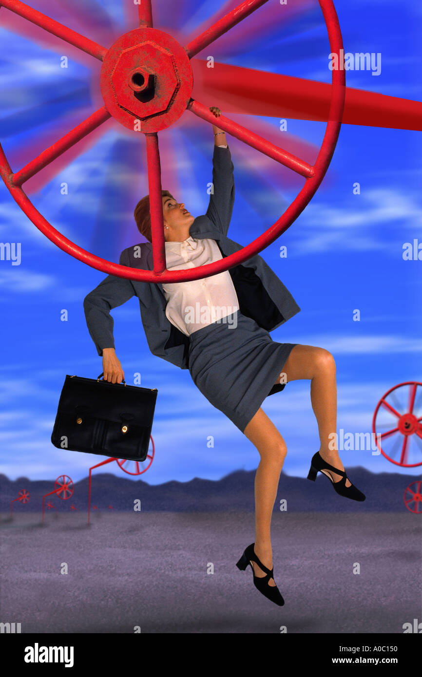 Businesswoman hanging from wheel Stock Photo - Alamy
