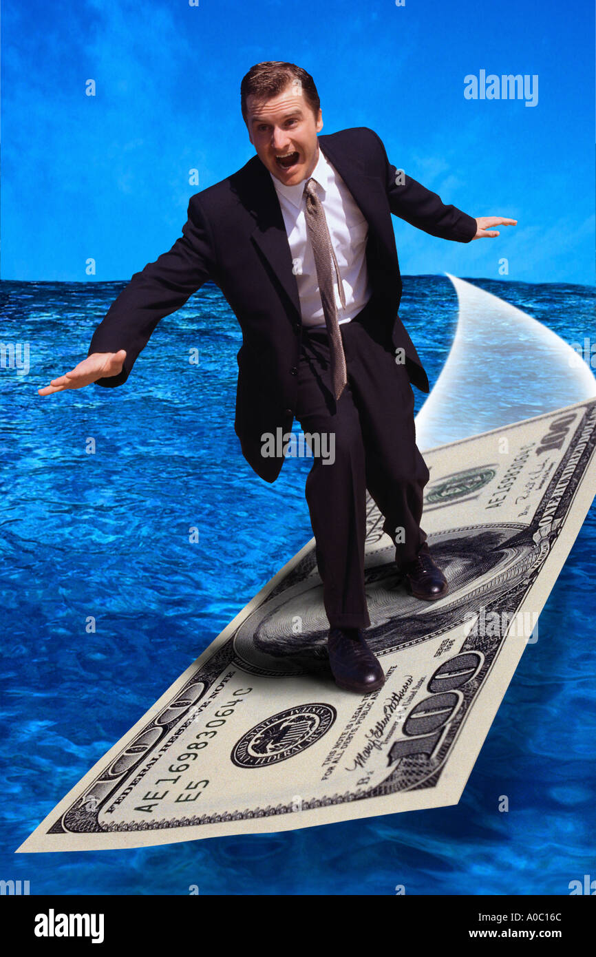 Businessman standing on flying money Stock Photo - Alamy