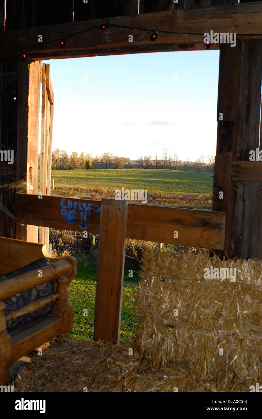 Stock image of a farm field framed by barn planks and a bale of hay ...
