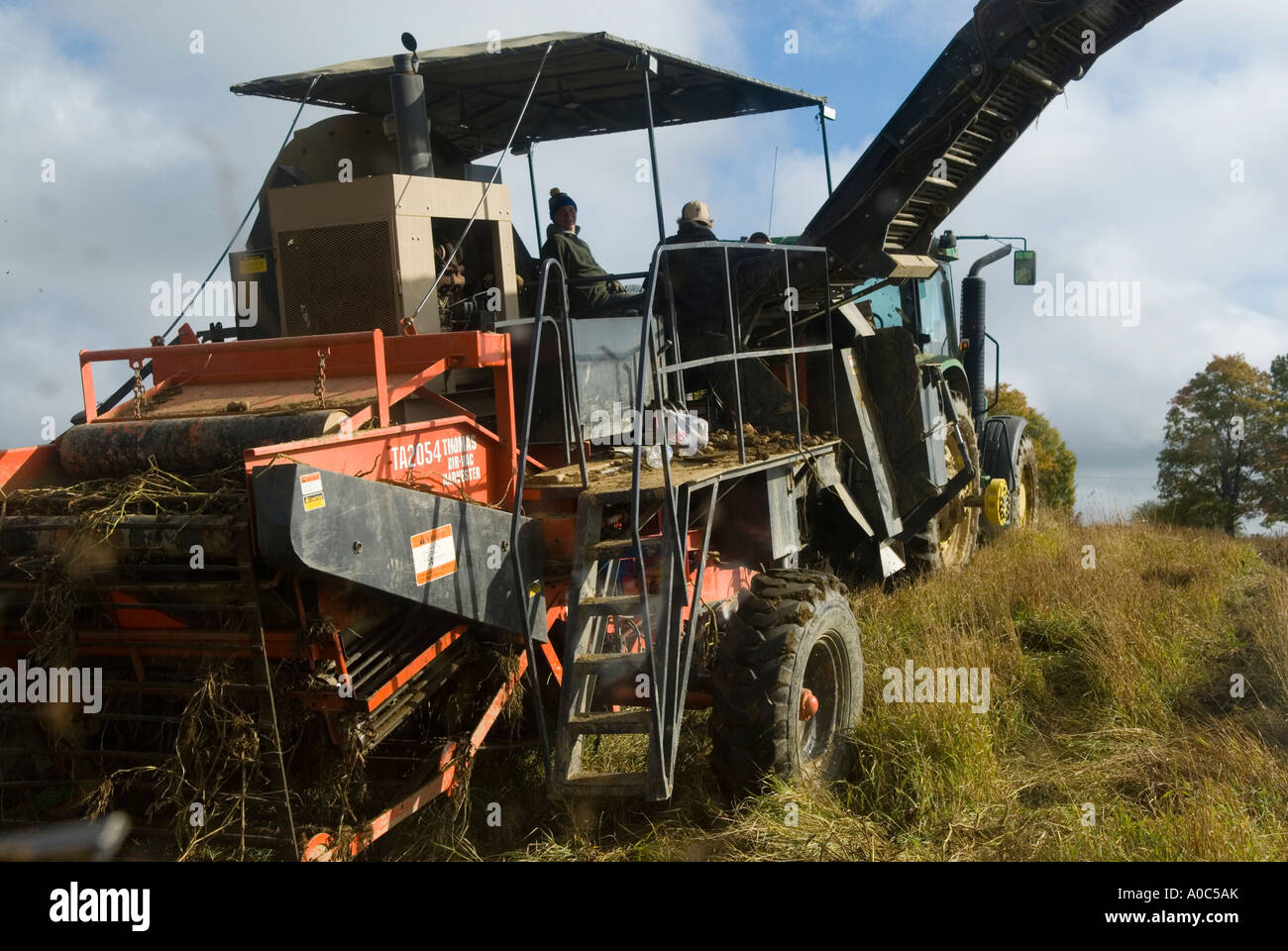 Stock image of a mechanical potato harvester and truck used to ...