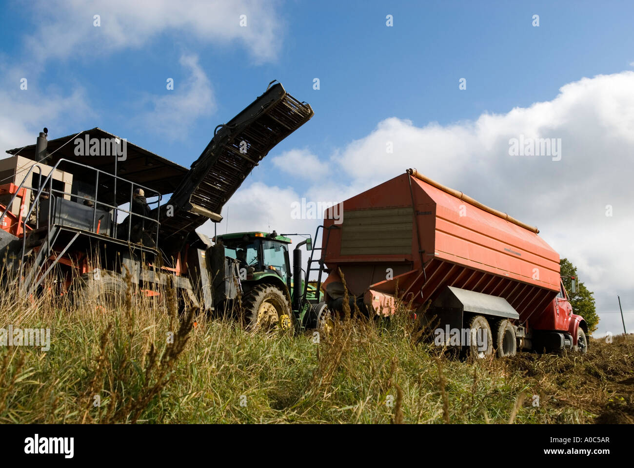 Stock image of a mechanical potato harvester and truck used to ...