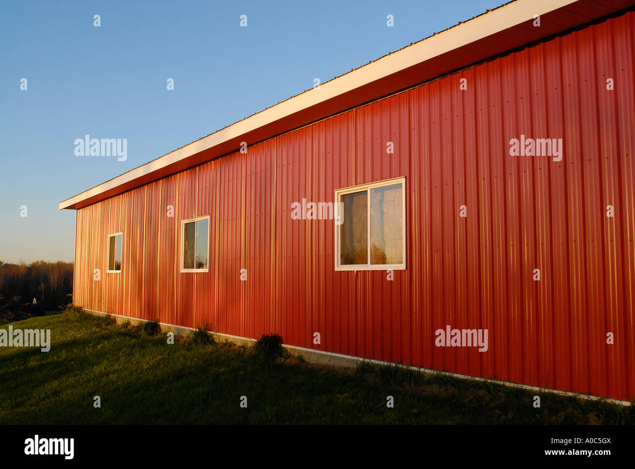 Stock image of a red metal barn at sunset Stock Photo - Alamy
