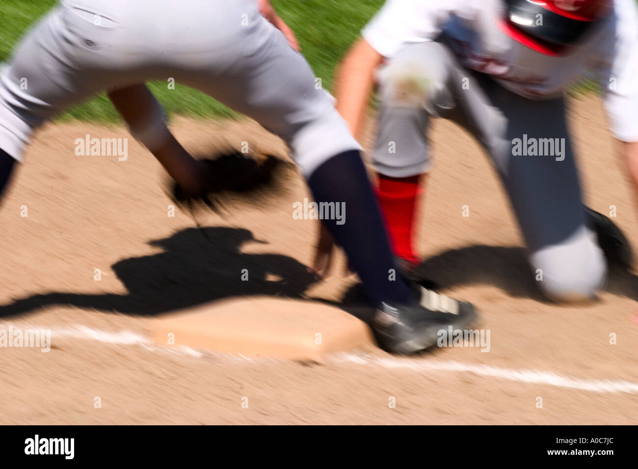 Preteen boy running back to first base while the boy playing first base ...
